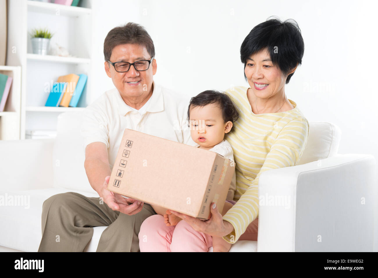 Asian family received an express courier parcel and open it at home ...