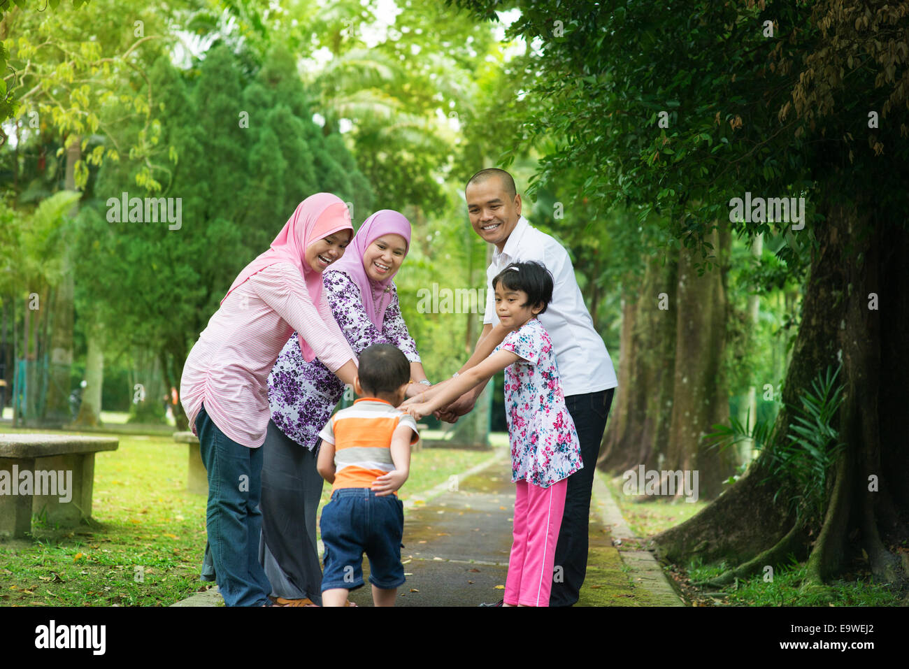 Happy family playing at outdoor garden park. Southeast Asian people ...