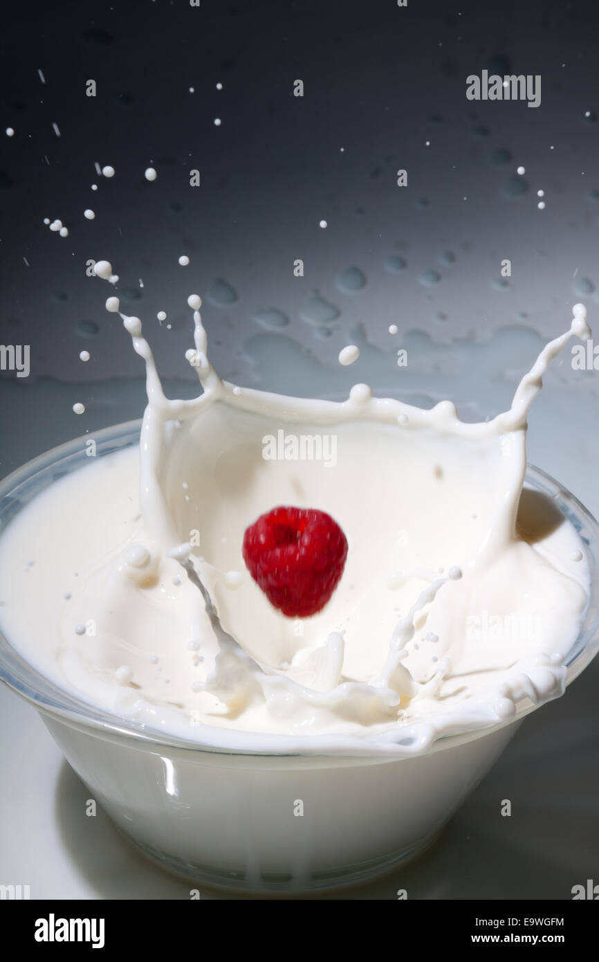 Milk splashing in a bowl by a falling Raspberry Stock Photo - Alamy