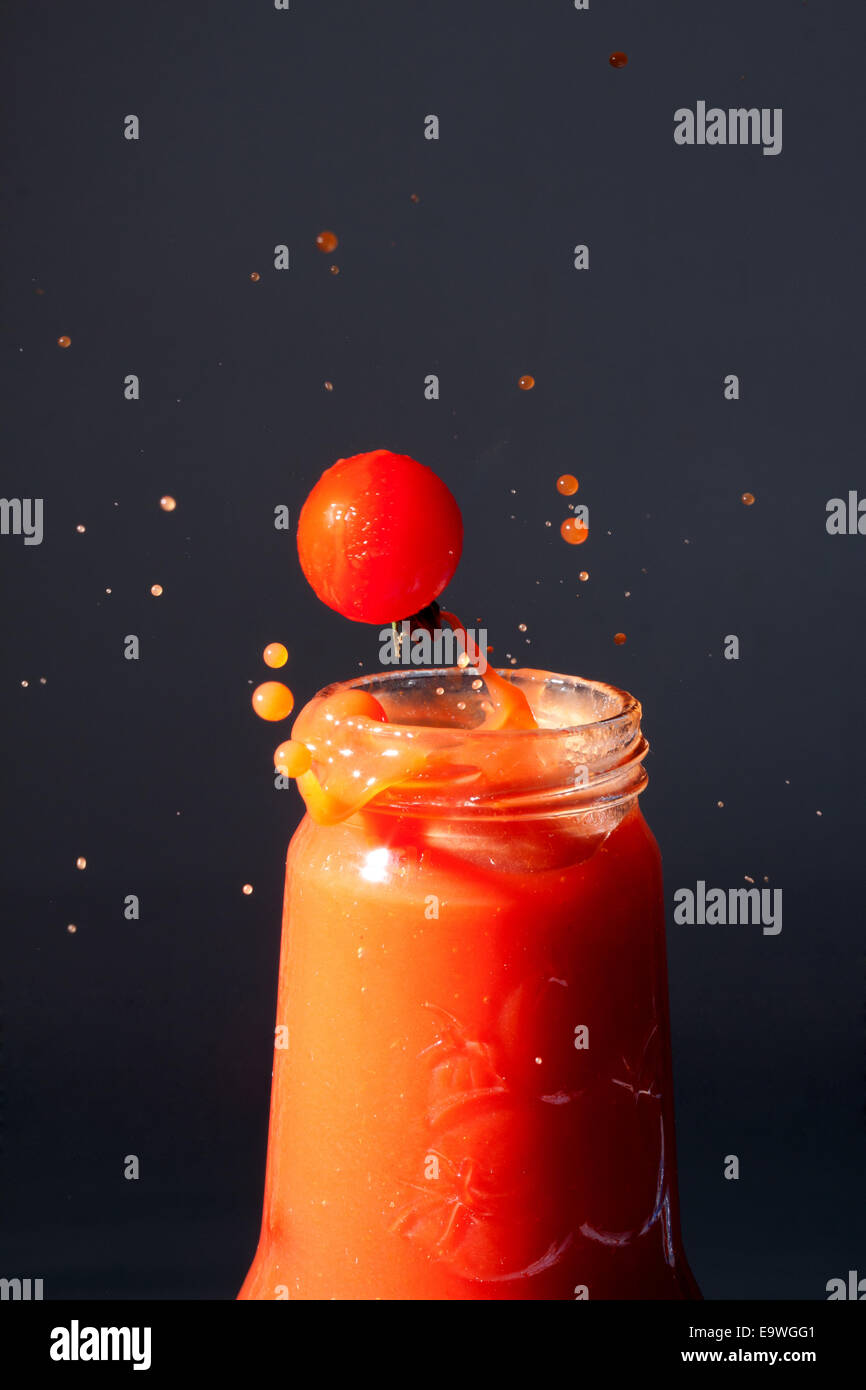 tomatoes fall into tomato juice in a bottle Stock Photo - Alamy