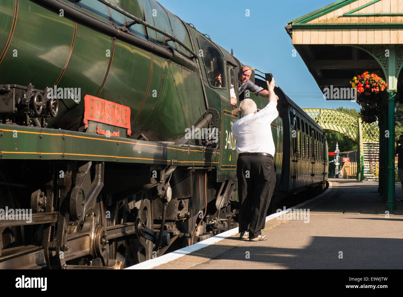 Railwayman and engine driver exchange the safety tokens before steam ...