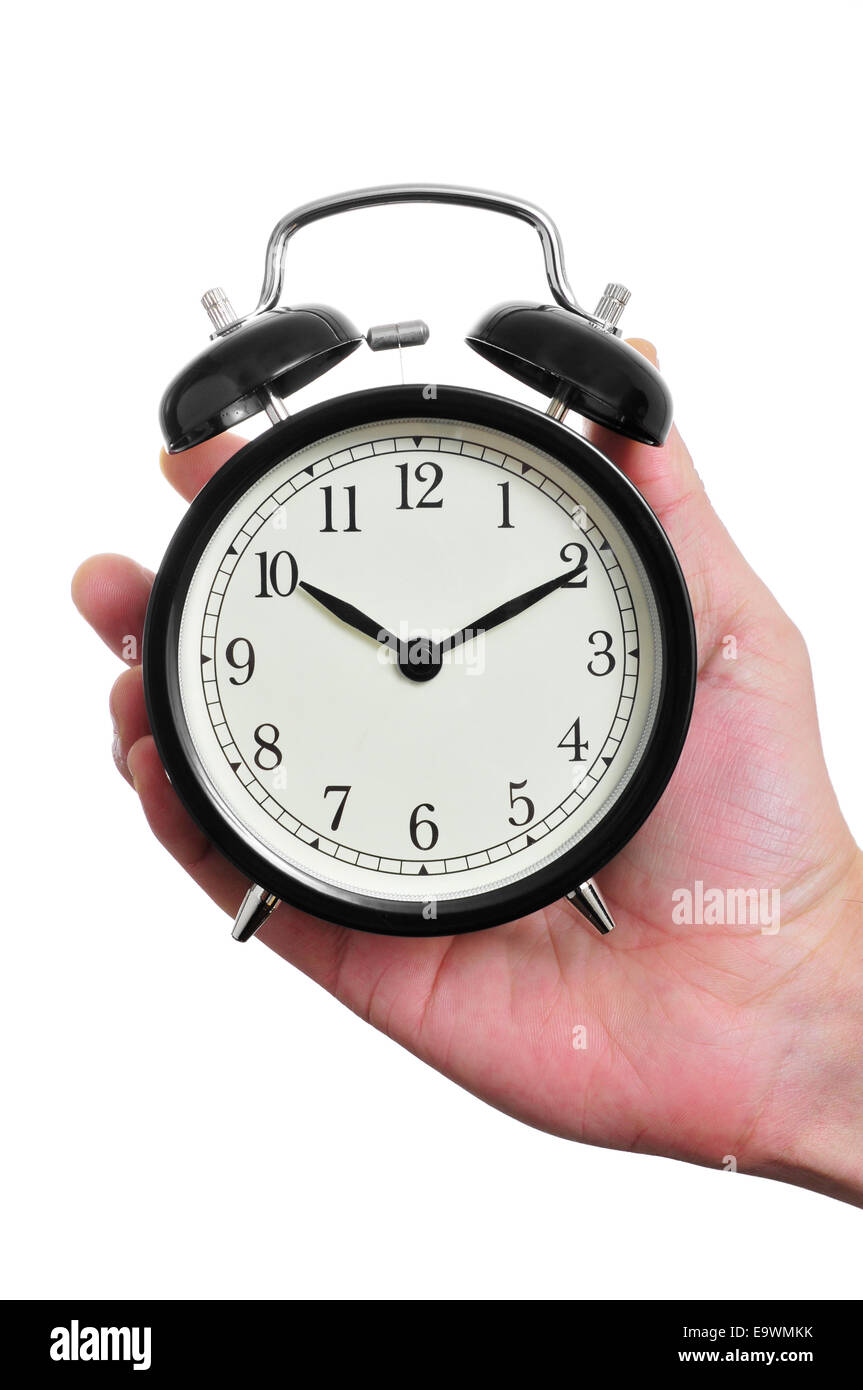 a man hand holding a typical mechanical alarm clock on a white ...