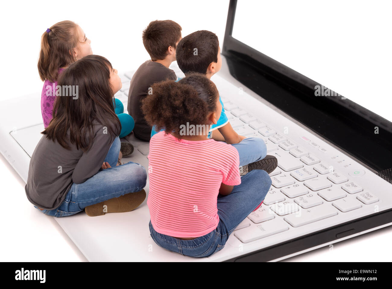 Group of young children in a laptop computer keyboard looking at the ...