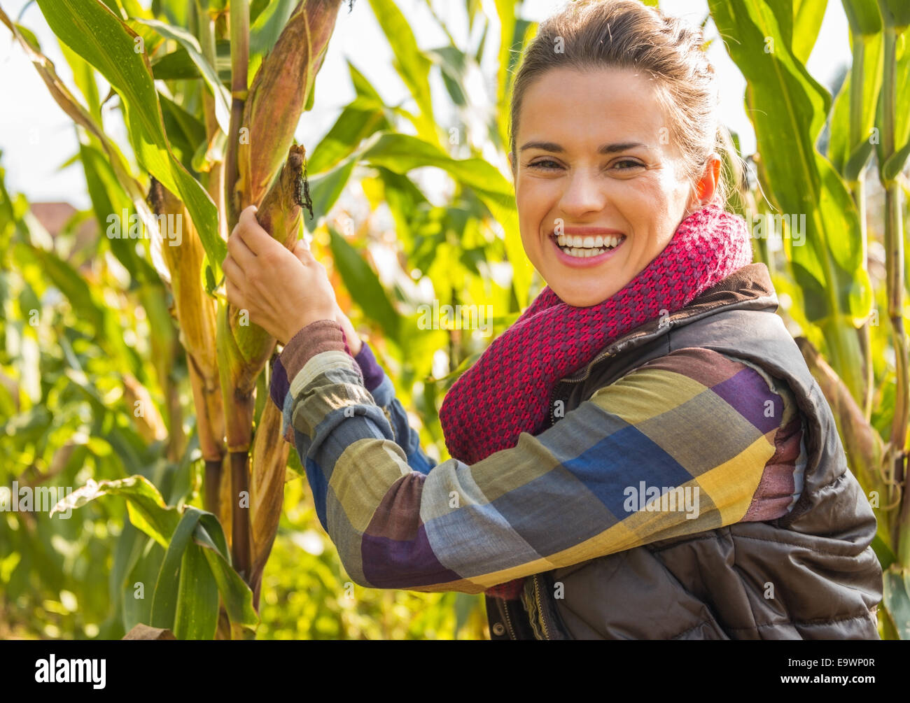 Portrait of happy young woman tearing corn Stock Photo - Alamy