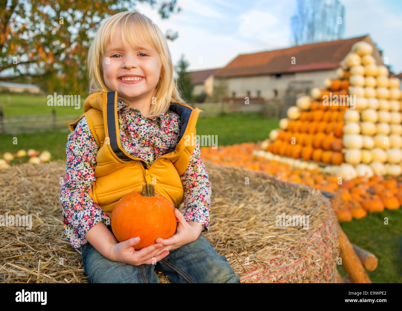 Kid sitting on pumpkin hi-res stock photography and images - Alamy
