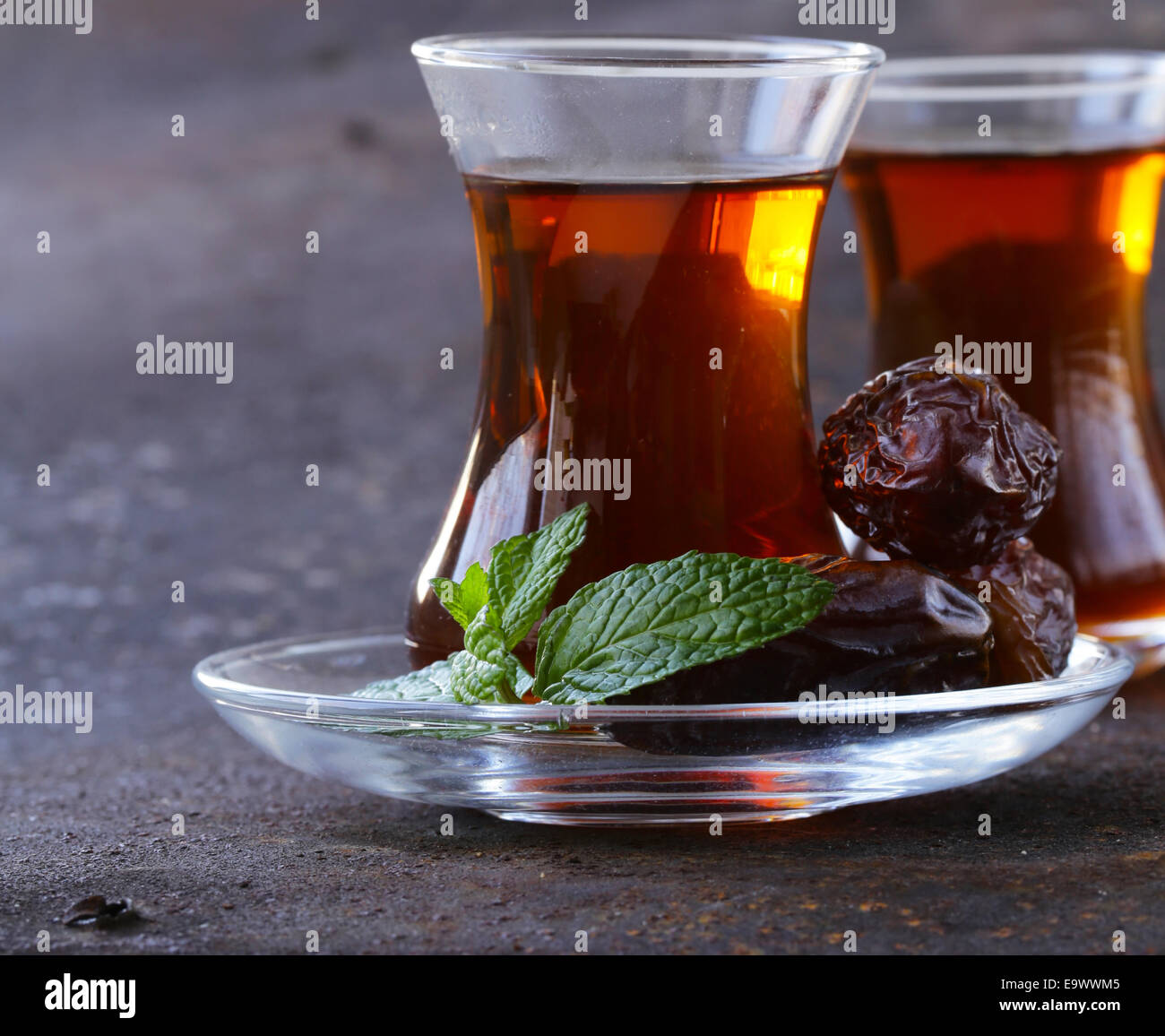 Turkish tea in traditional glass with sweet dates Stock Photo - Alamy