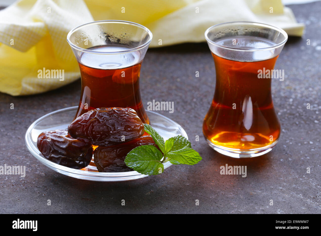 Turkish tea in traditional glass with sweet dates Stock Photo - Alamy
