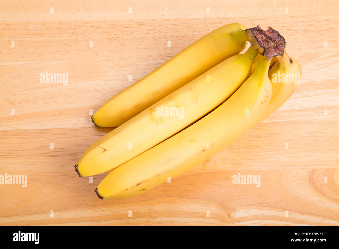 Bunch of yellow bananas on a wood table Stock Photo - Alamy