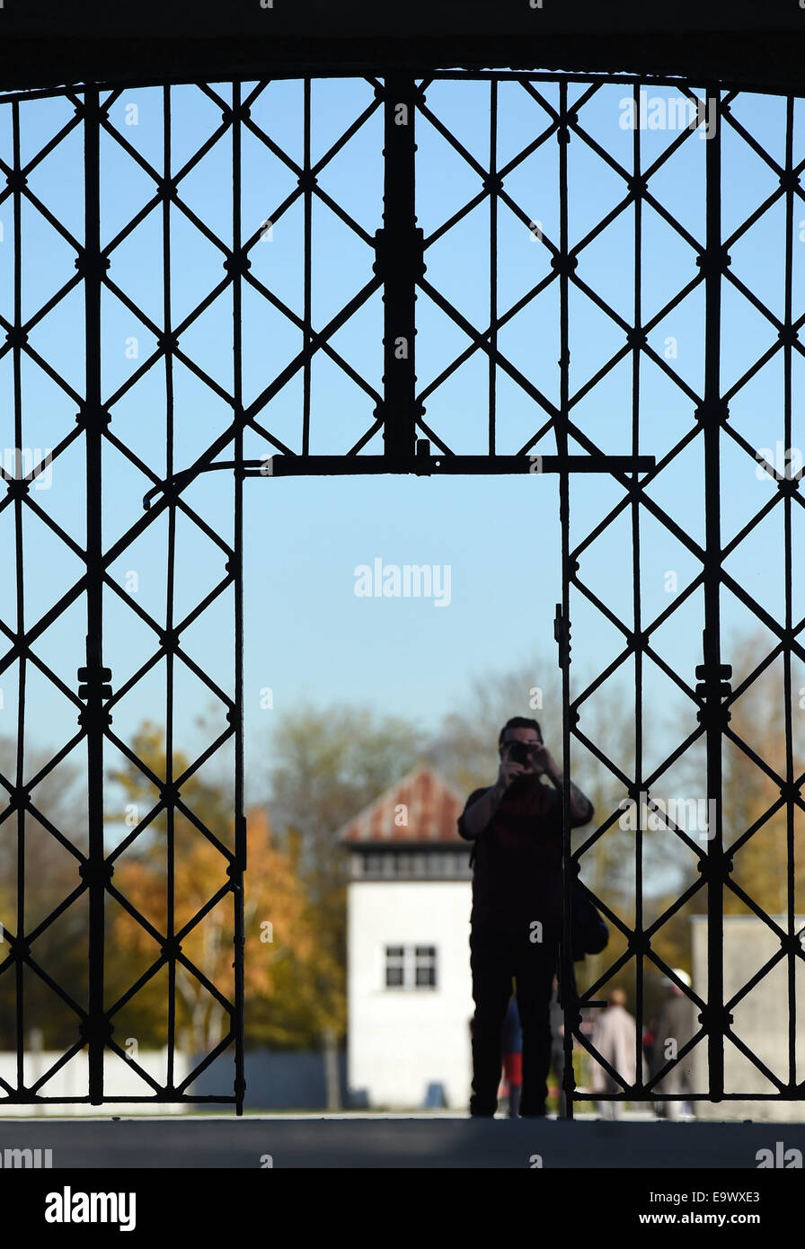 A man walks through the gate, part of which, bearing the Nazi slogan ...
