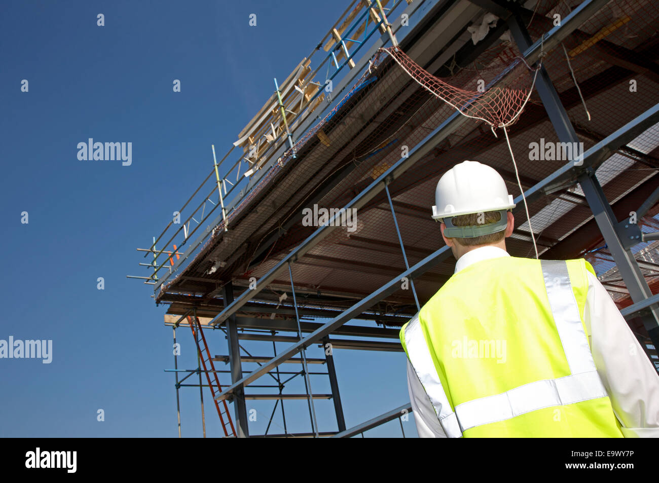 Builder Looking at Construction Site Stock Photo - Alamy