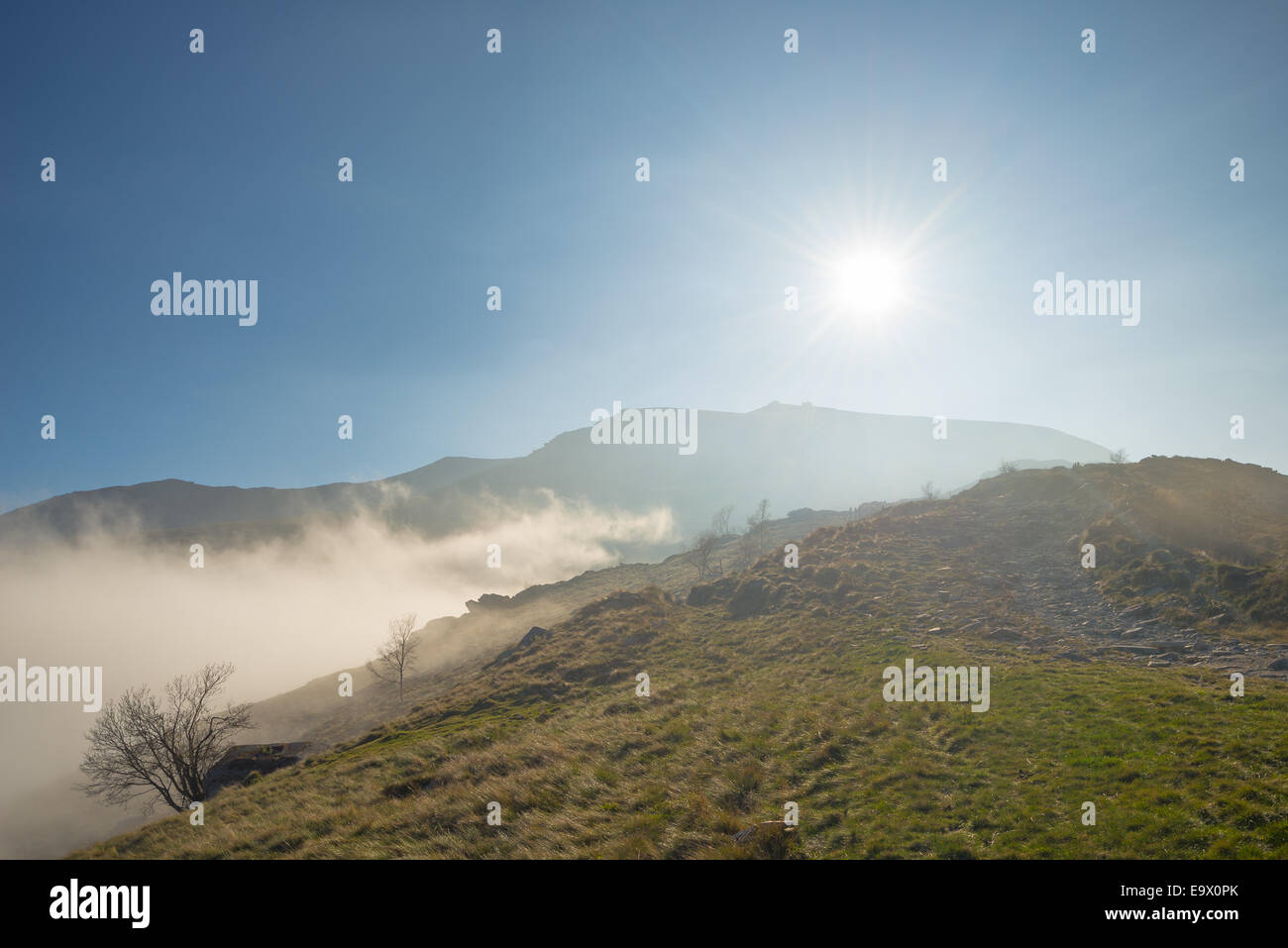 Clouds and fog gathering on the mountain ridge in a sunny afternoon ...