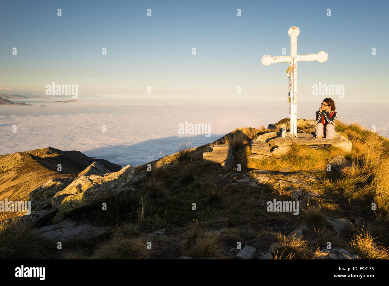 Female hiker reaching her goal at the mountain top and sitting near the ...