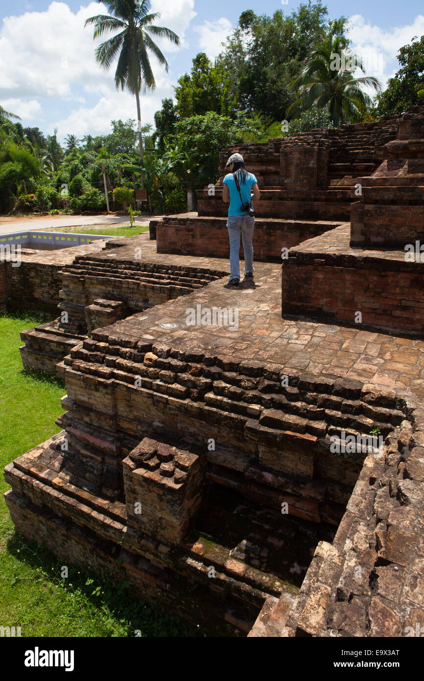A tourist guide examines Wat Long, a Srivijaya kingdom legacy built in ...