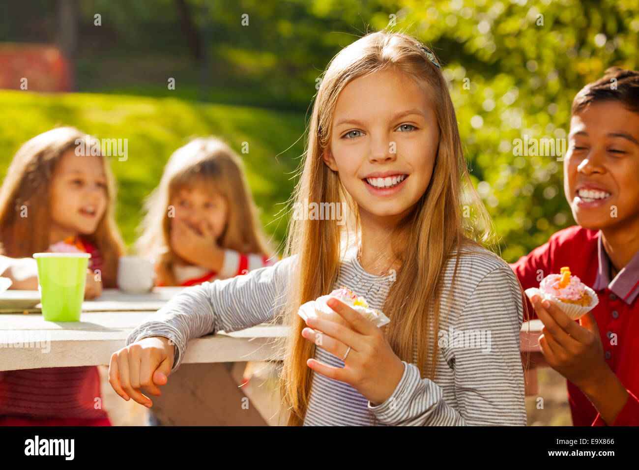 Beautiful girl and happy children sitting outside Stock Photo - Alamy