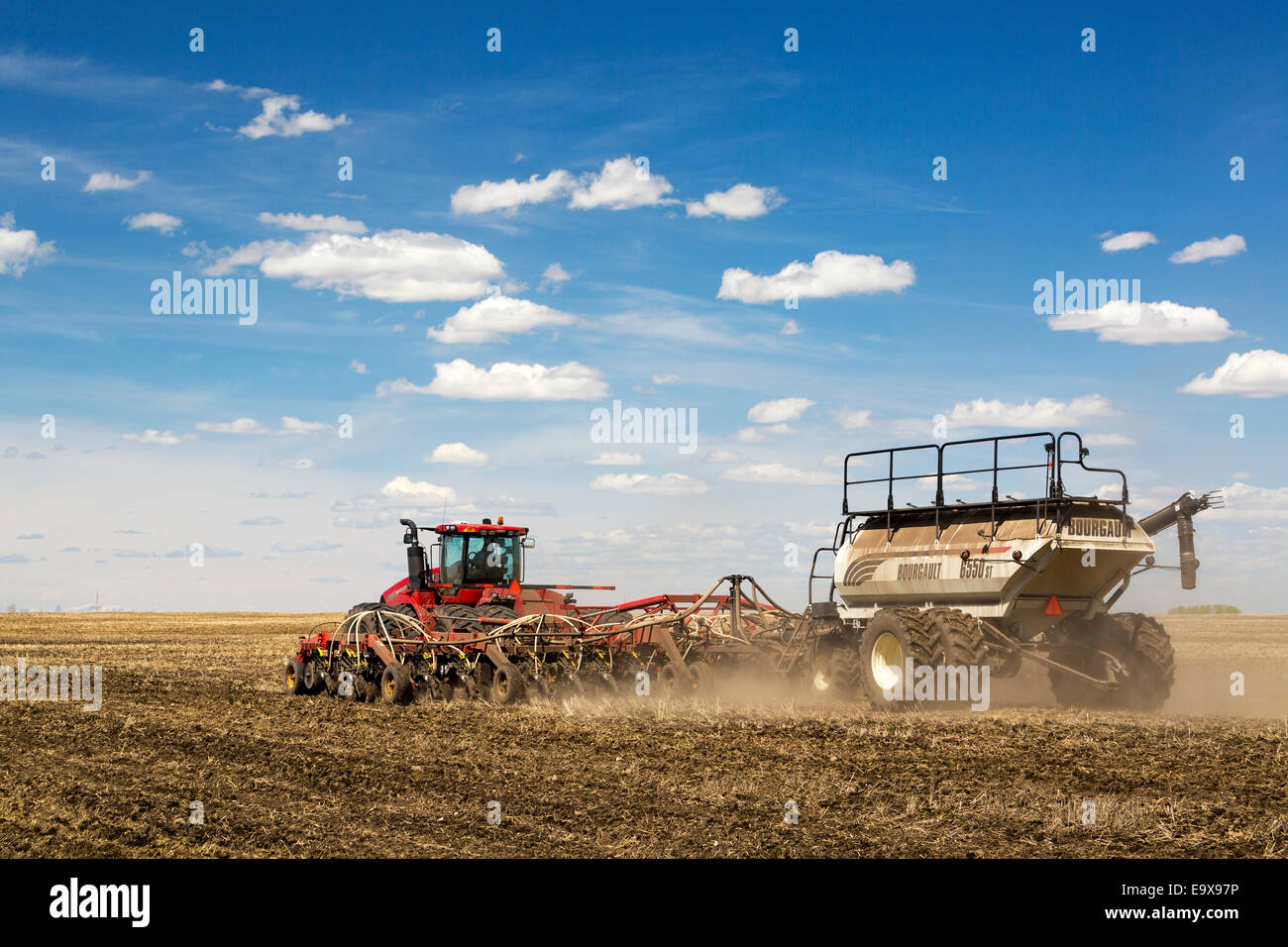Tractor seeding field with clouds and blue sky; Alberta, Canada Stock ...