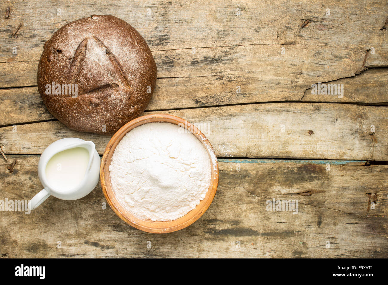 Loaf of bread with bakery ingredients and copy space on old wooden ...