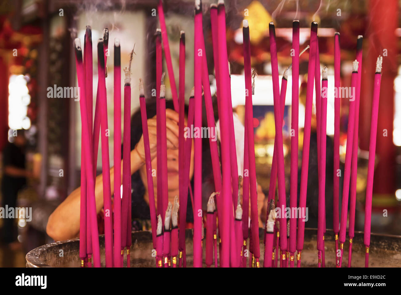 Woman depositing joss sticks in an incense burner in a Sam Pho Kong ...