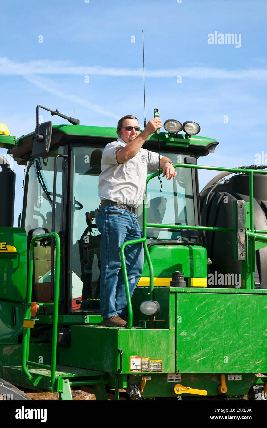 Agriculture - A sprayer operator checks wind speed to determine if it ...