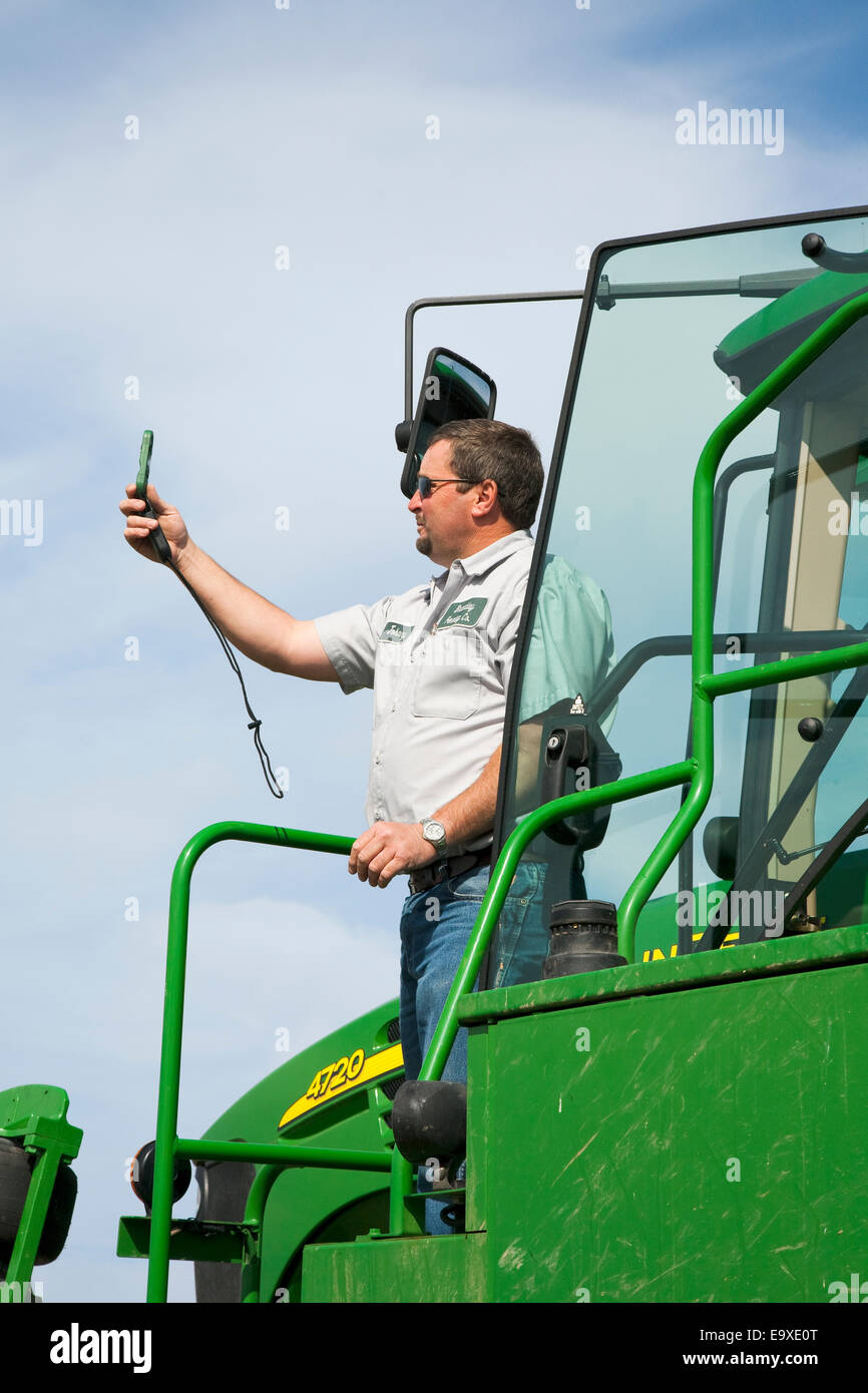 Agriculture - A sprayer operator checks wind speed to determine if it ...