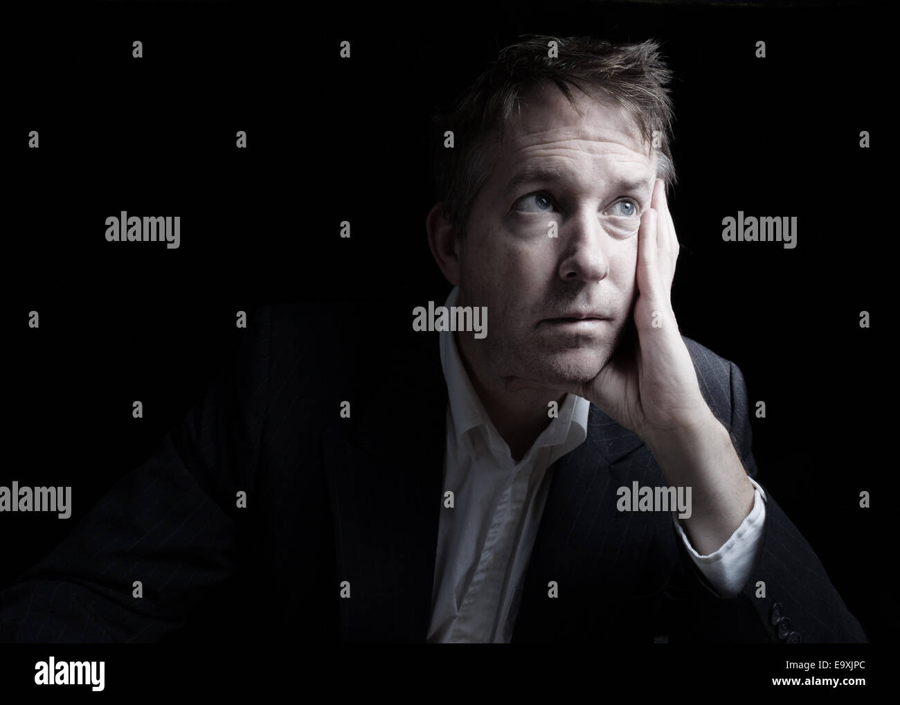 Portrait of businessman looking hopeless while working late at night on ...