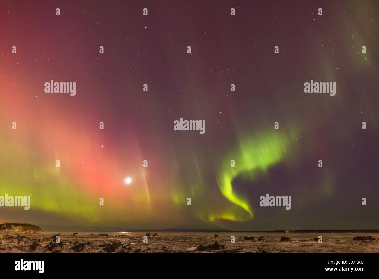 Northern Lights and moon in the sky above the snow covered mudflats of ...