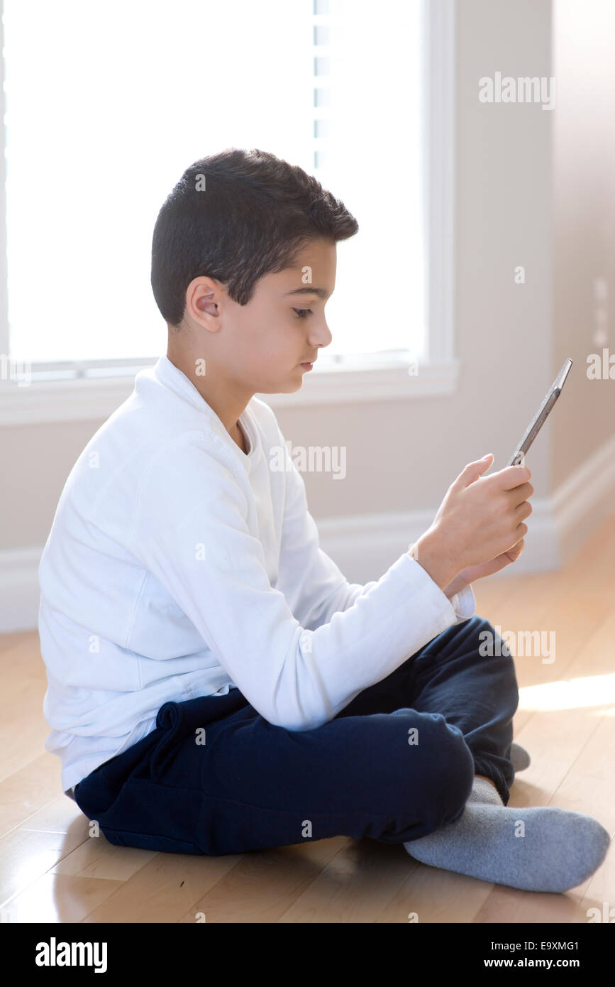 Young boy sitting with an iPad tablet computer Stock Photo - Alamy