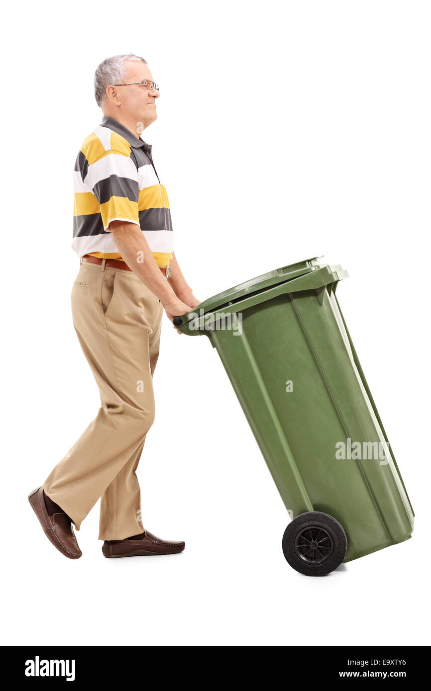 Full length portrait of a senior pushing a large green trash can ...