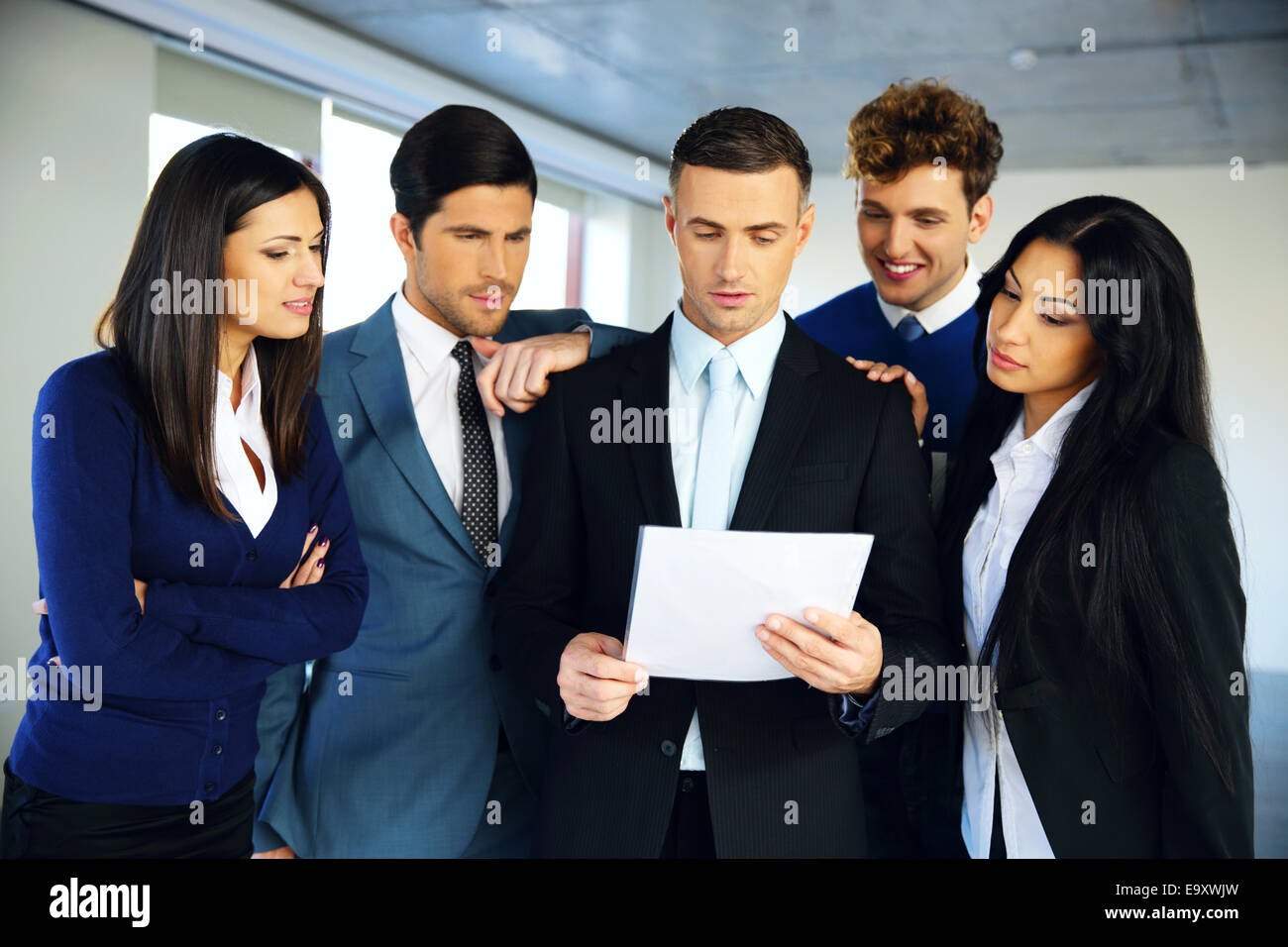 Business people reading a document together Stock Photo - Alamy