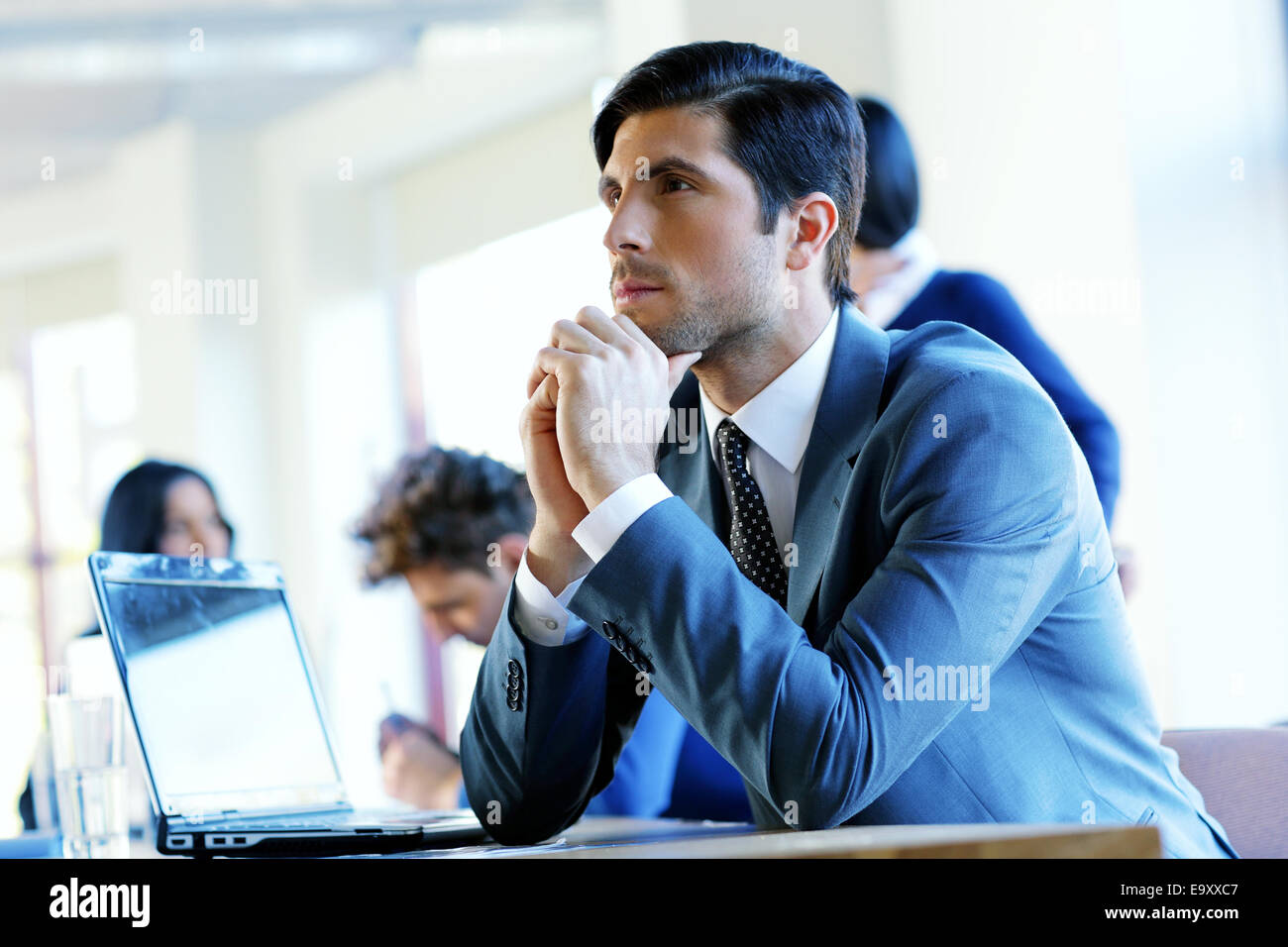 Portrait of a pensive businessman sitting at the table in office Stock ...