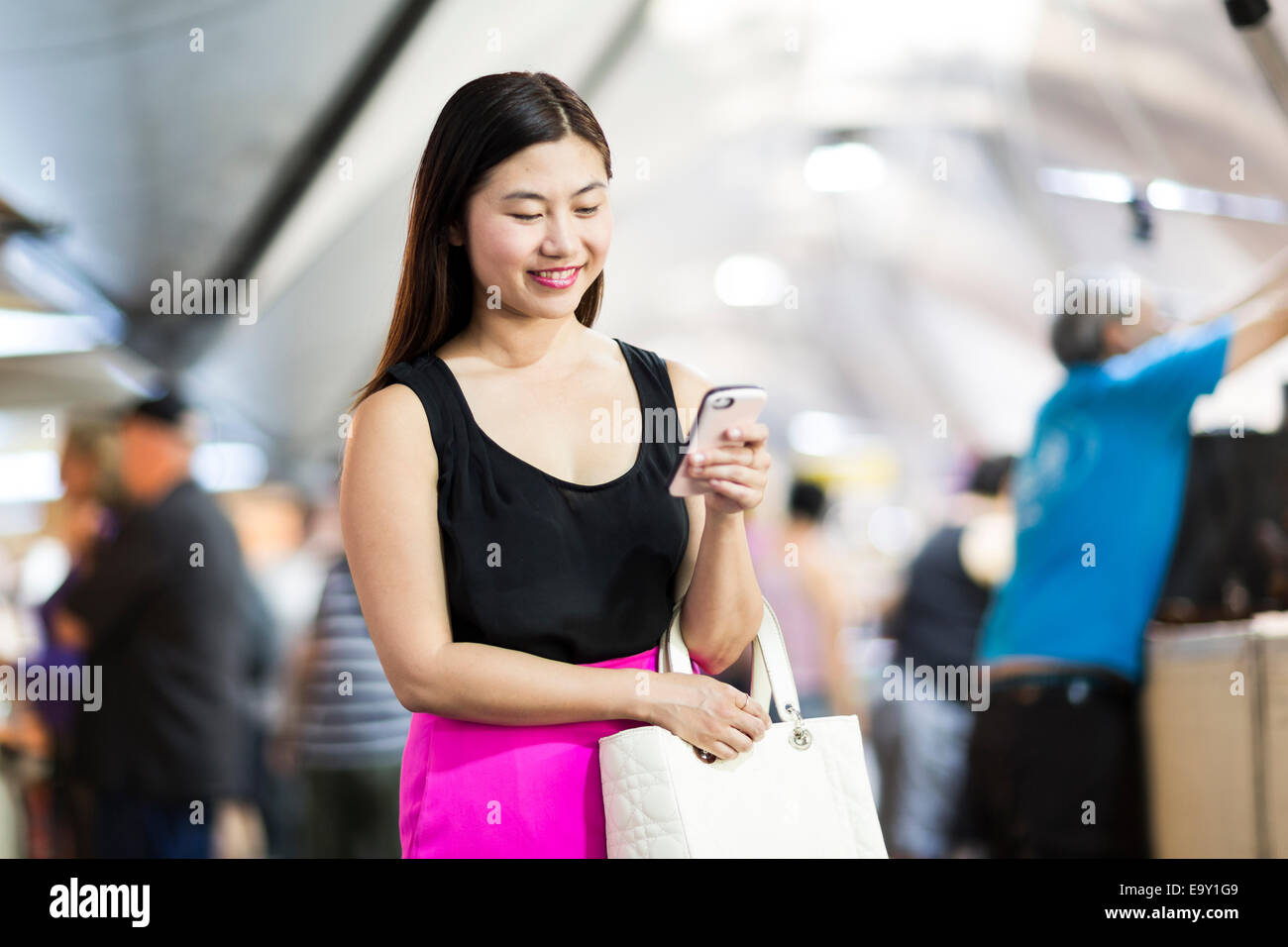 A young Asian woman using her mobile device Stock Photo - Alamy