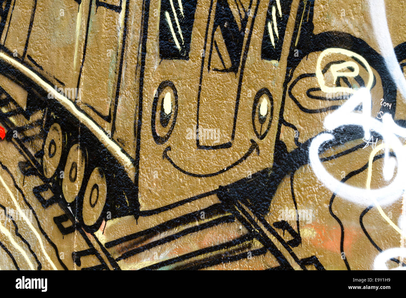 Berlin wall graffiti gold train smiley face track Stock Photo - Alamy