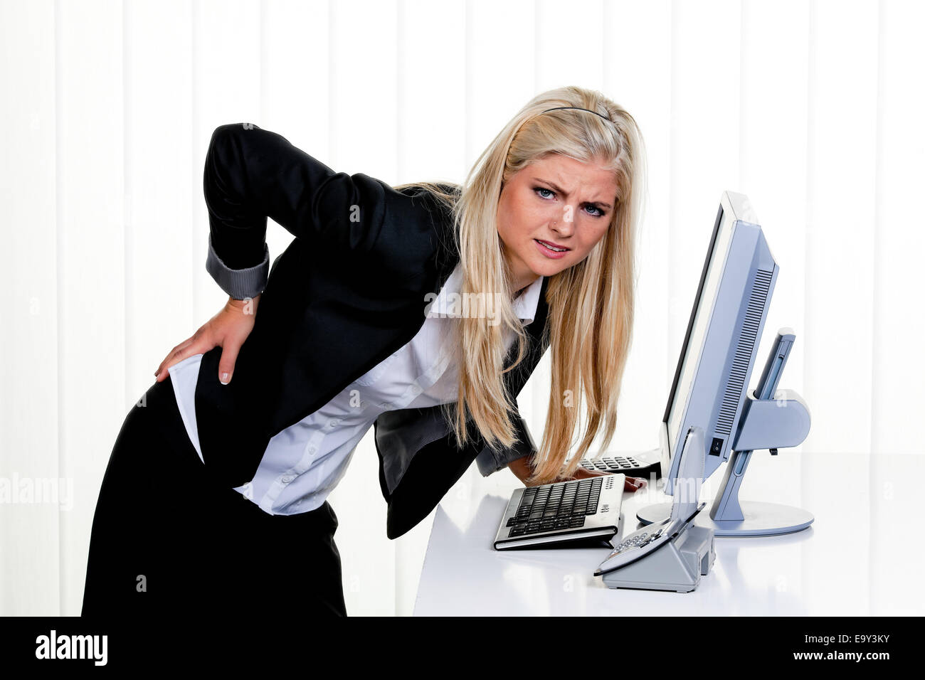 young woman with aching back in office Stock Photo - Alamy