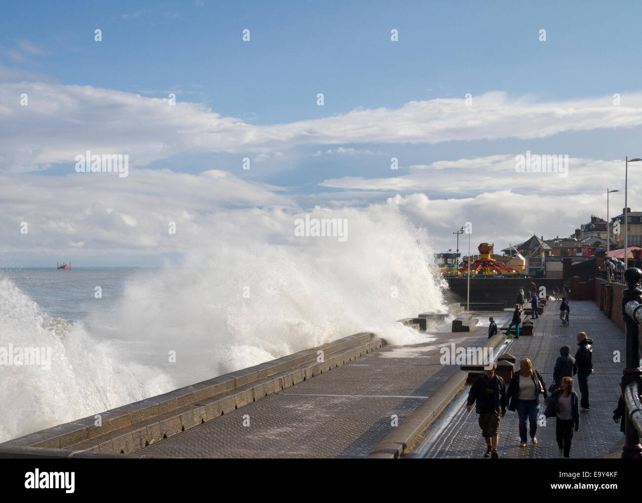 Bridlington, England, August 10th: people standing next to big waves ...