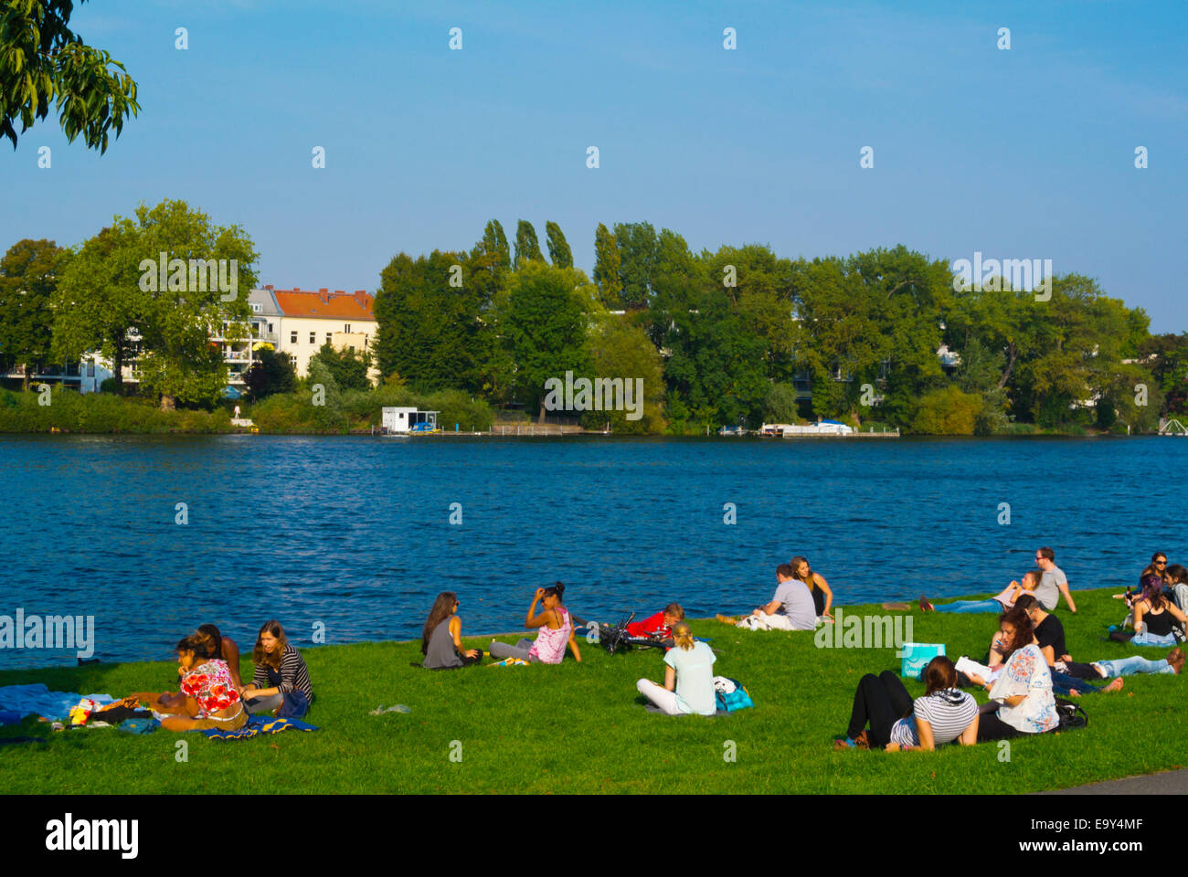 People on grass next to River Spree, Treptower park, Treptow district ...