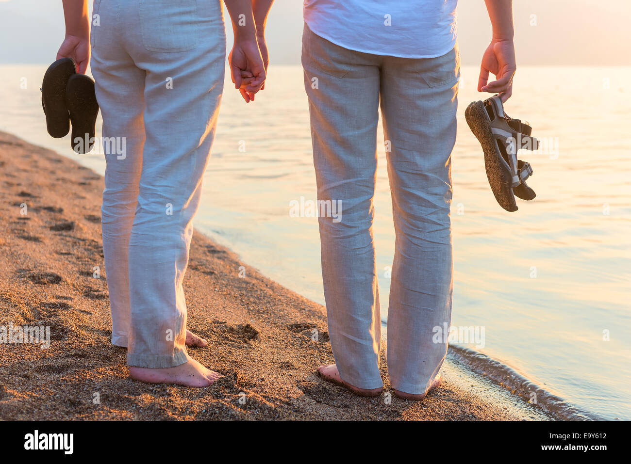barefoot people with the shoes in hand by the sea Stock Photo - Alamy