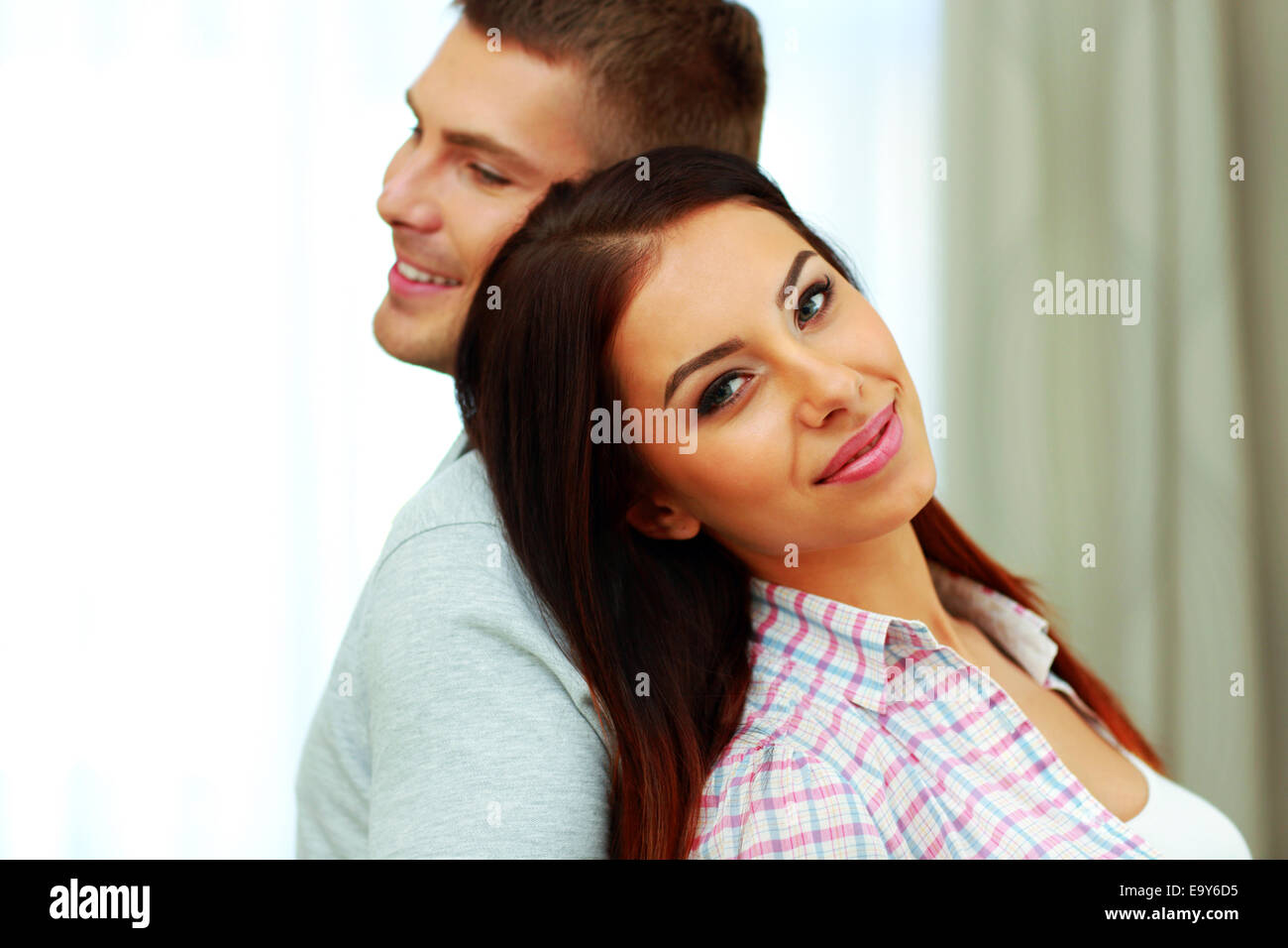 Young happy couple standing back to back Stock Photo - Alamy
