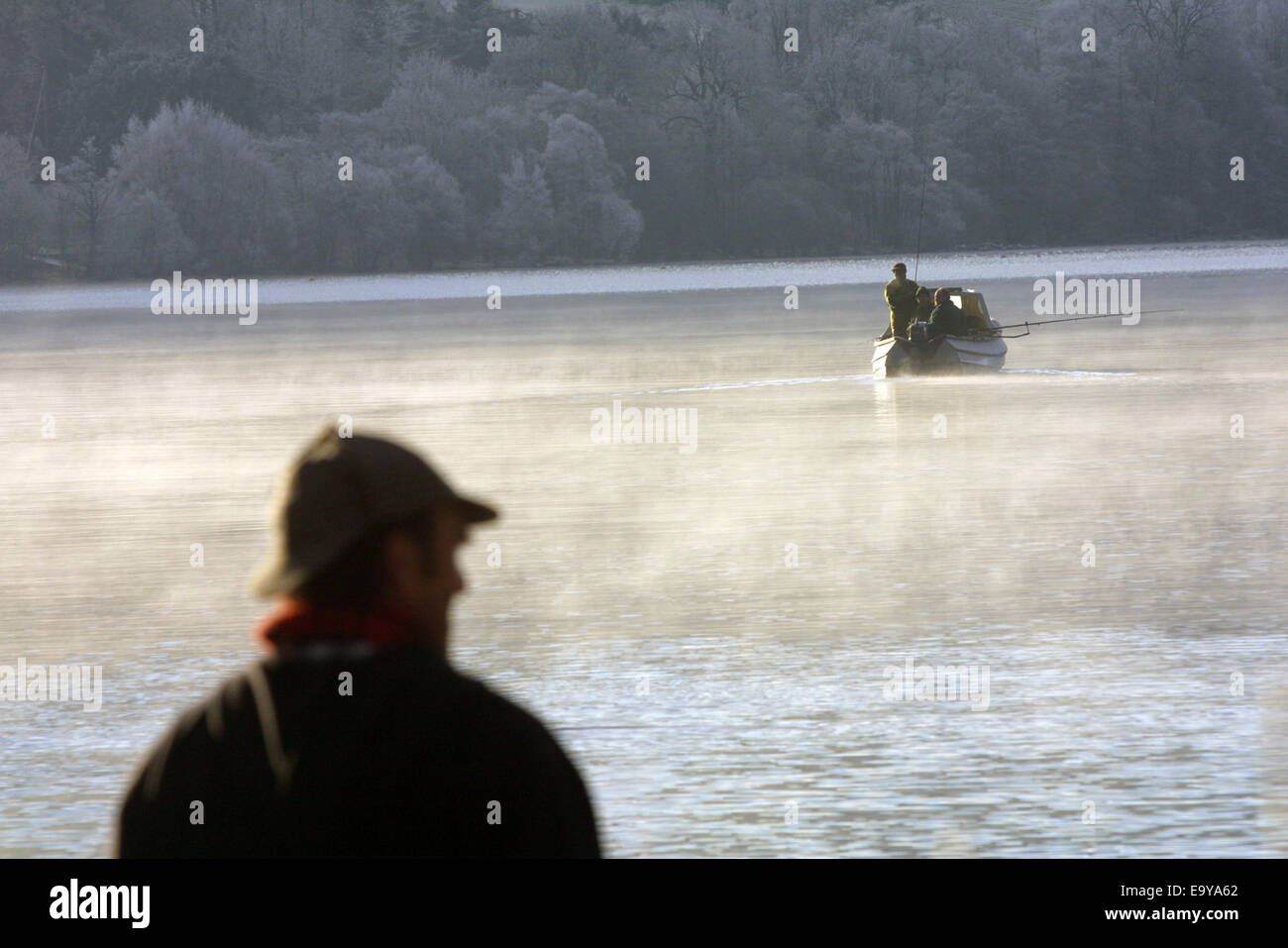 A man watching anglers fishing from a boat in the waters of the river ...
