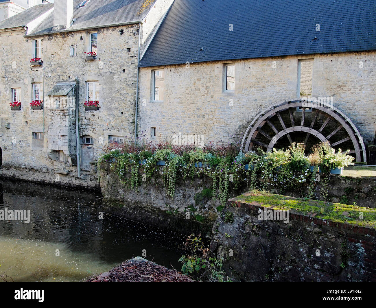 Picturesque undershot waterwheel and ancient buildings behind the ...