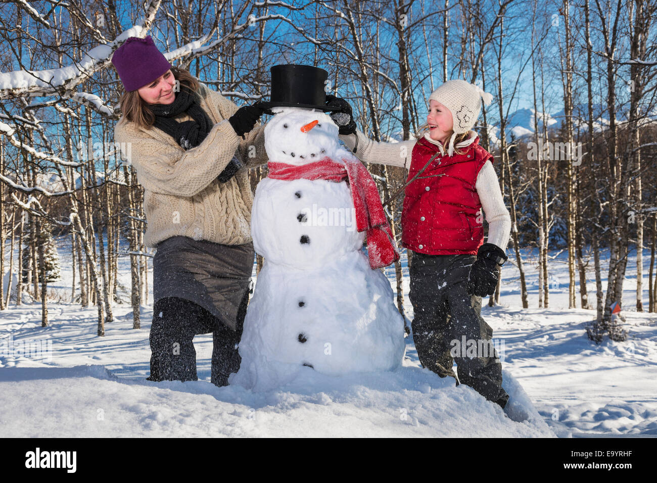 Mother and young daughter building a snowman, Russian Jack Springs city ...