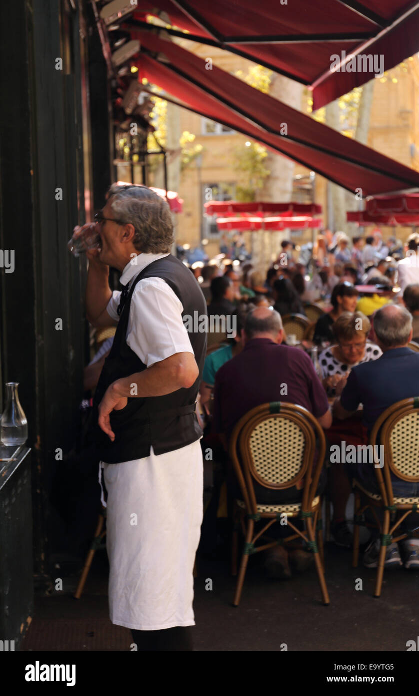 A waiter in Aix-en-Provence takes a drink Stock Photo - Alamy