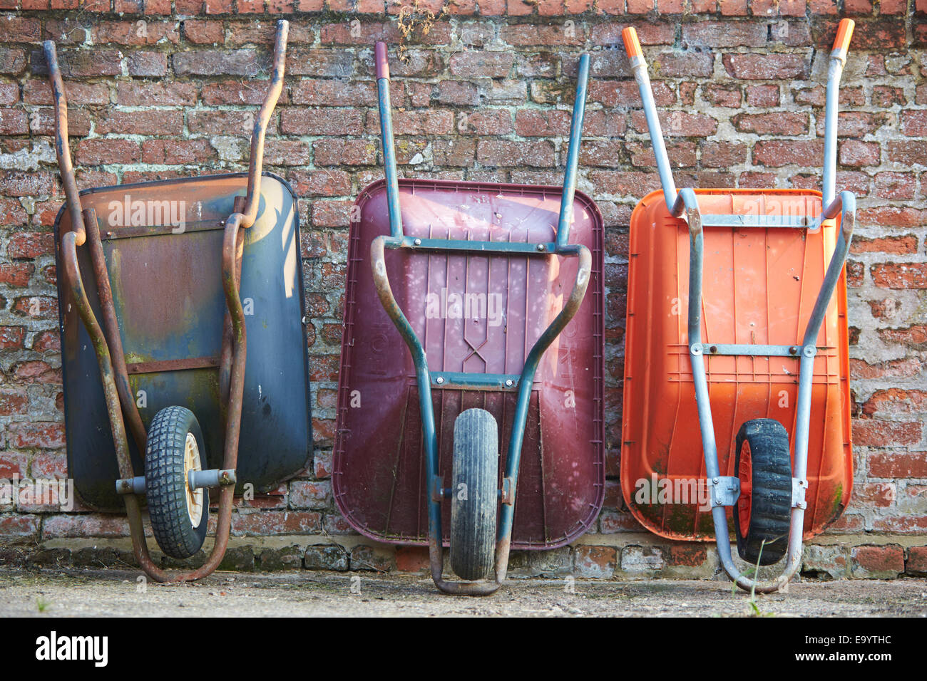 Three old wheelbarrows against a wall Stock Photo - Alamy