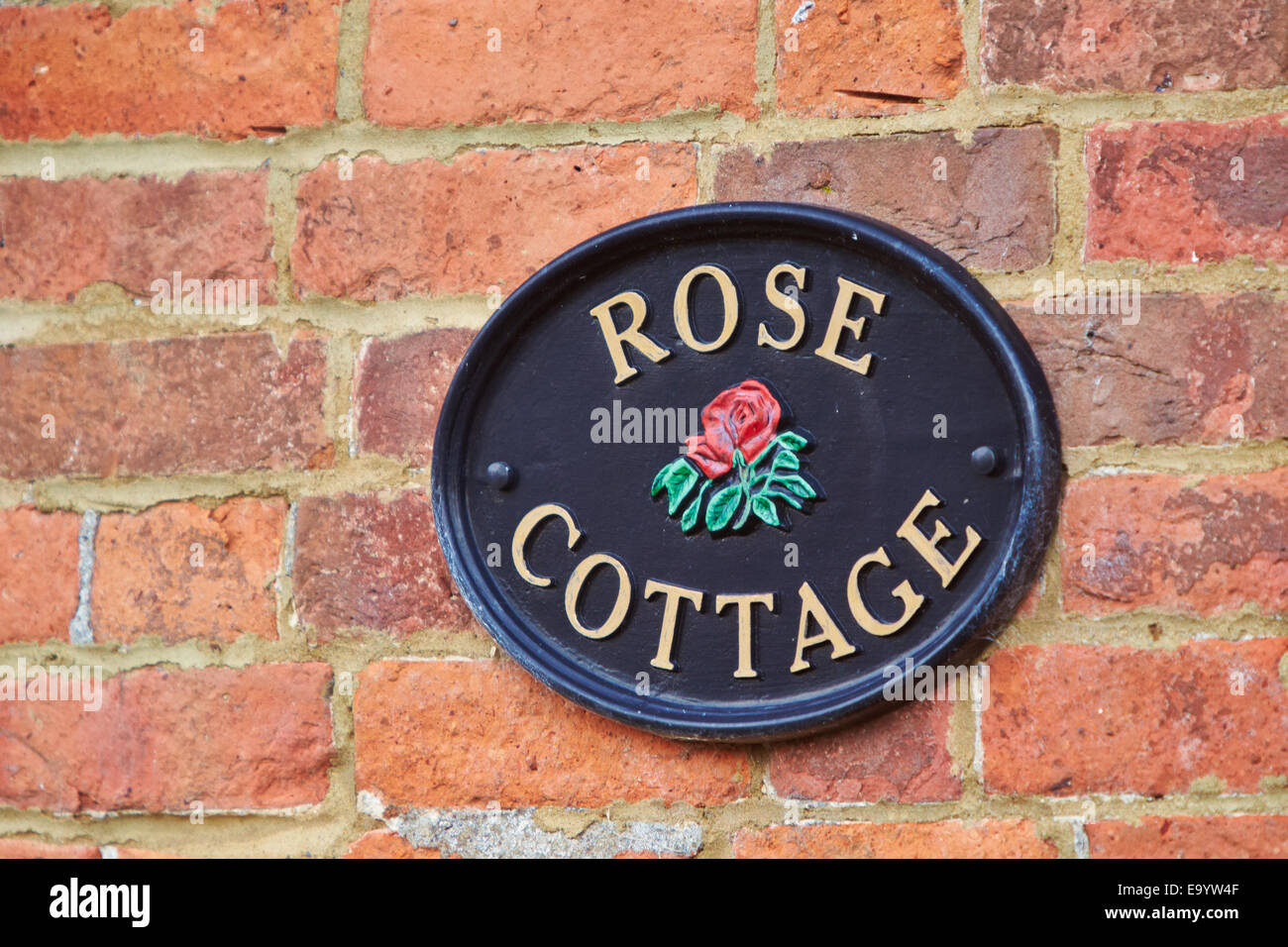 Rose cottage sign on a brick wall Stock Photo - Alamy