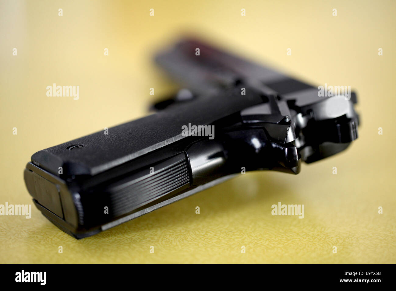 Gun on yellow background Stock Photo - Alamy