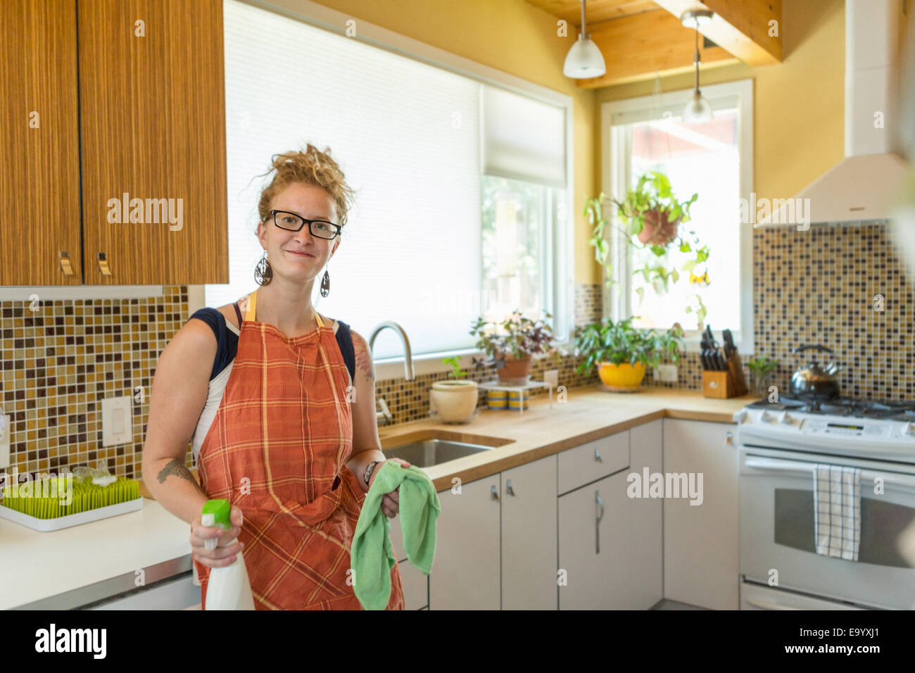 Young woman cleaning kitchen with green cleaning products Stock Photo ...