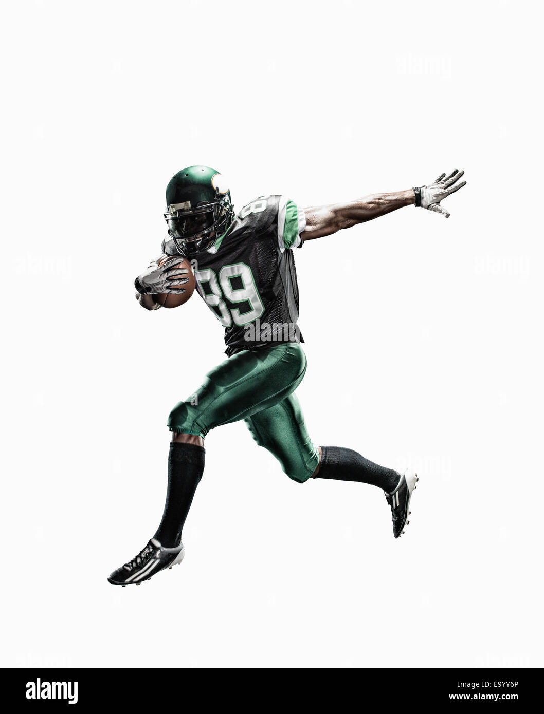 Studio shot of male football player running with ball Stock Photo - Alamy