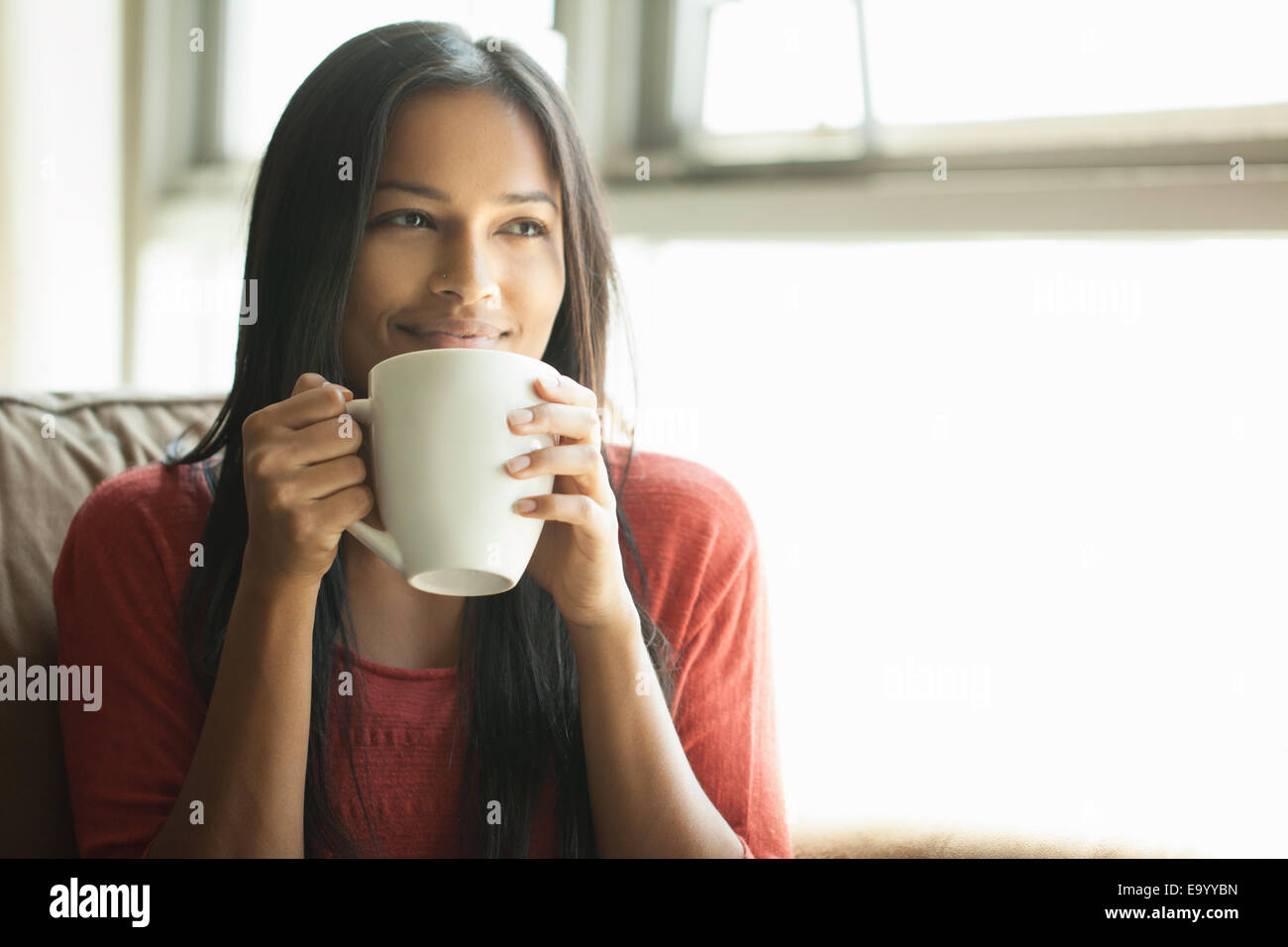 Woman having coffee at home Stock Photo - Alamy