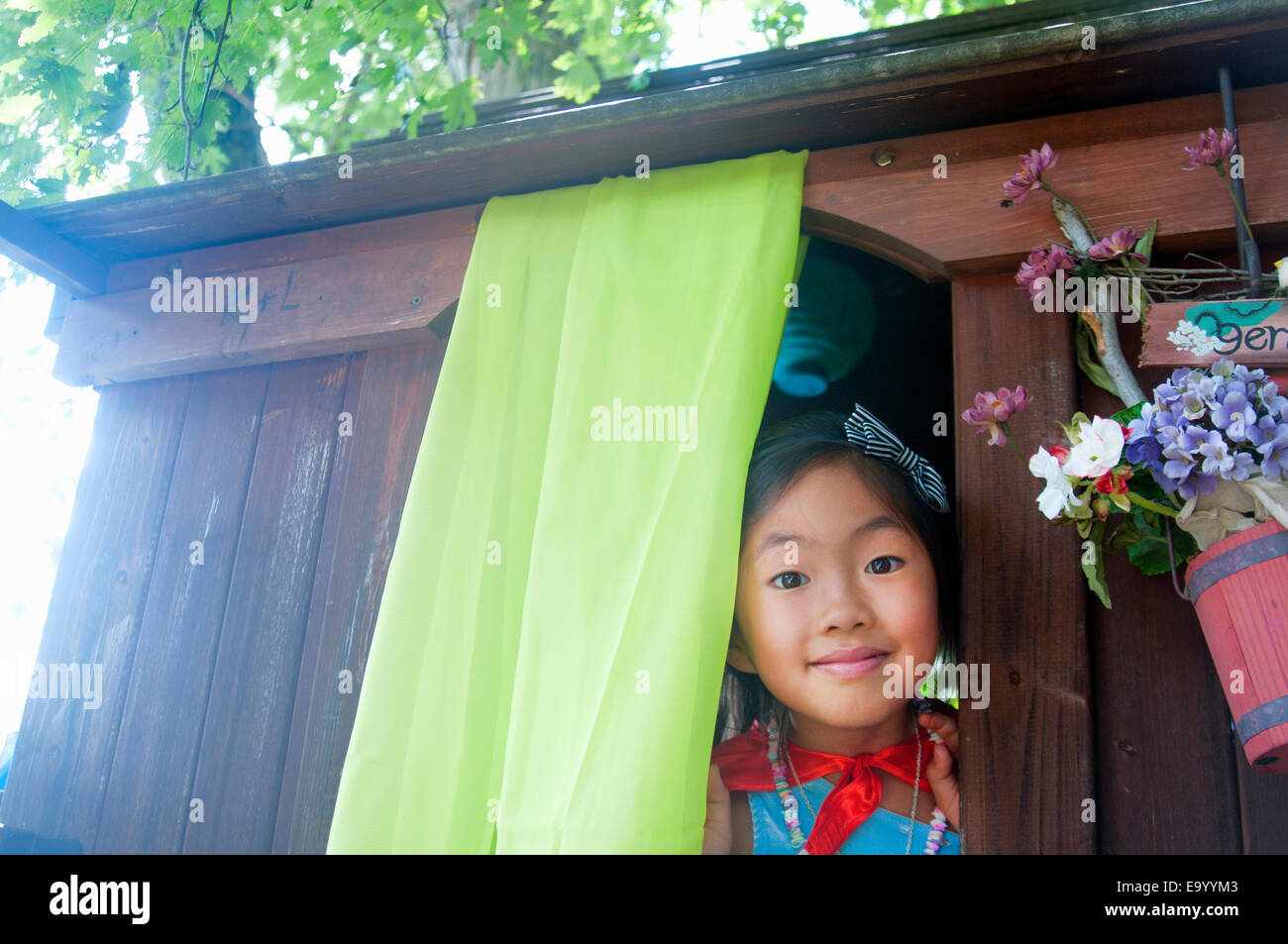 Young girl looking out from tree house Stock Photo - Alamy