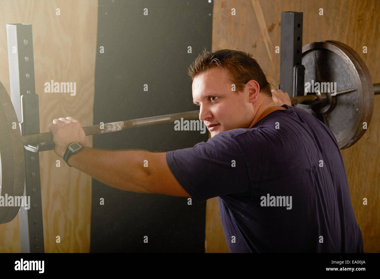 Young male weightlifter preparing to lift barbell in gym Stock Photo ...