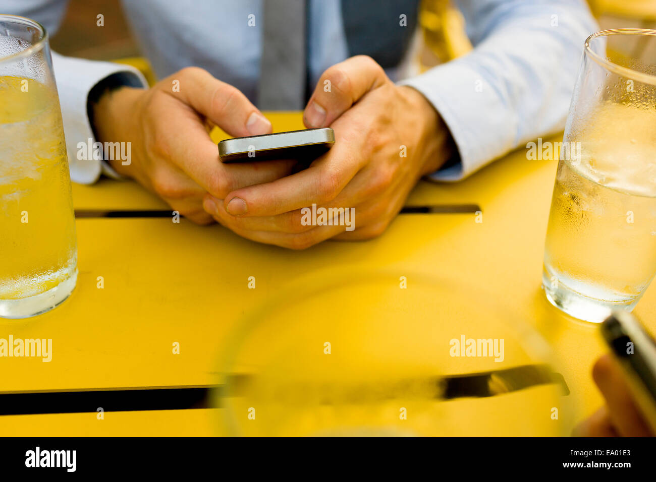Hands of young man texting on smartphone at sidewalk cafe Stock Photo ...