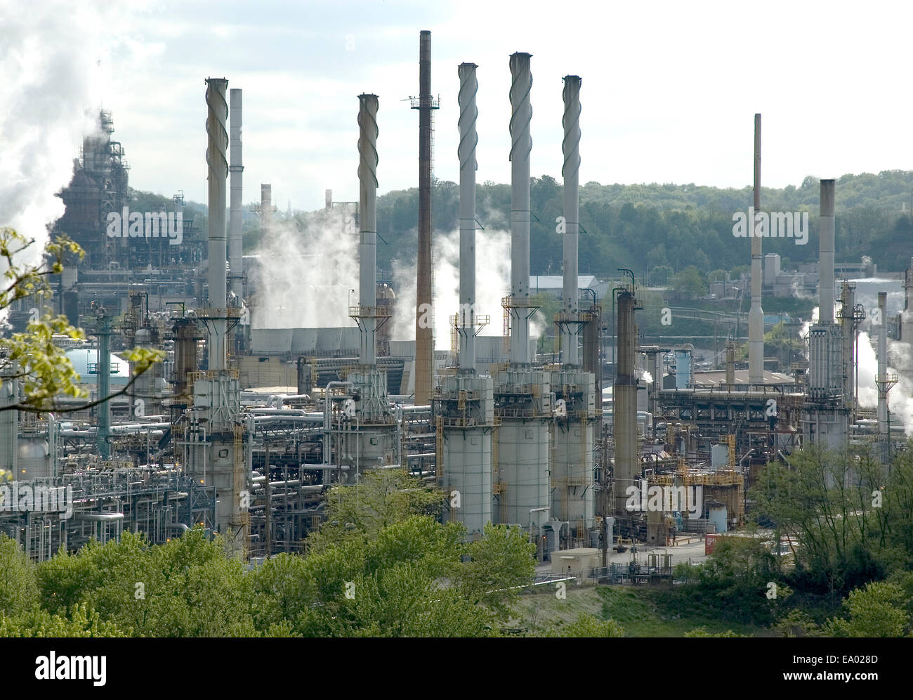 Oil refinery releasing steam in the background Stock Photo - Alamy